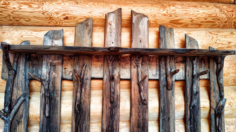 Rustic Wooden Shelf with Branch Hooks Attached, Against a Log Cabin ...