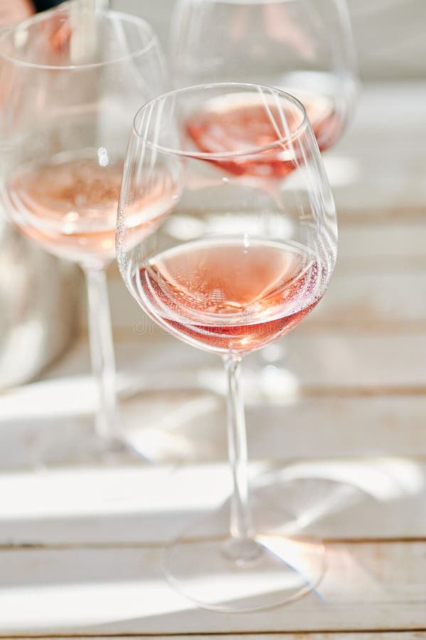 Rustic Wooden Table with Numerous Glasses of Pink Alcoholic Beverages ...