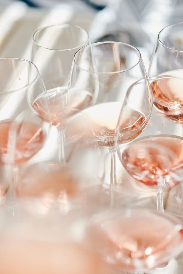 Rustic Wooden Table with Numerous Glasses of Pink Alcoholic Beverages ...