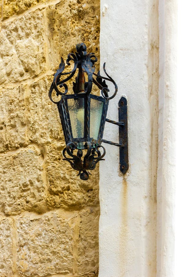 Rustic Wrought Iron Lantern on a Stone Wall in Bright Daylight Stock ...