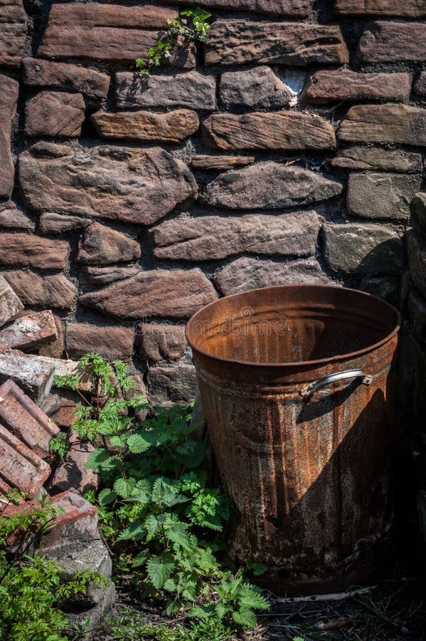Rusty Bin by Stone Wall stock image. Image of broken - 118851557