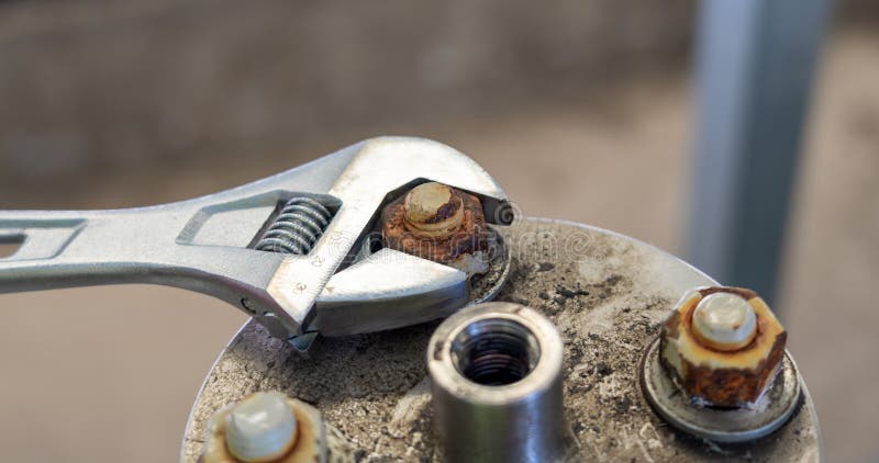 A Rusty Bolt Being Loosened with an Adjustable Wrench during ...