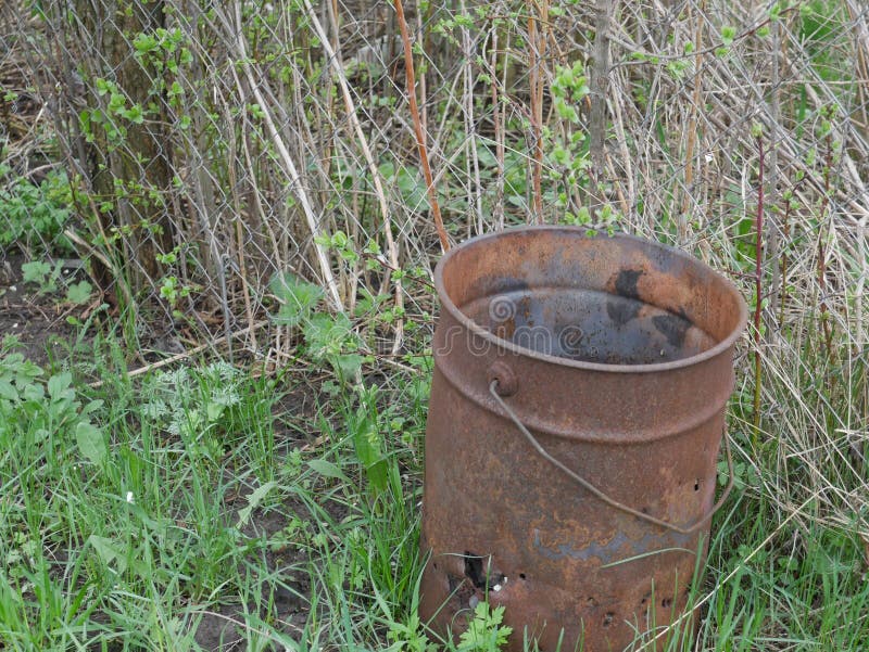 Rusty Bucket on the Green Grass Stock Photo - Image of rusty, kettle ...