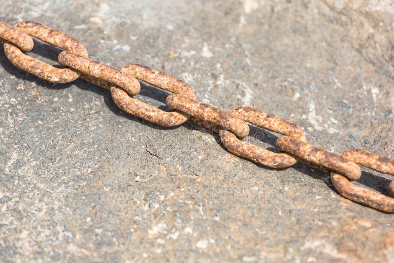 Rusty chain on a rock stock image. Image of strength - 64496723