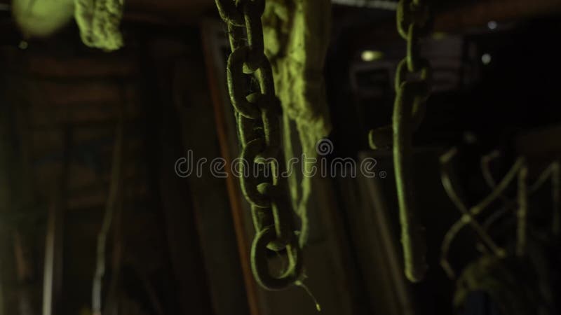 Rusty Chains Hang from the Ceiling and Dangle in an Abandoned Basement ...