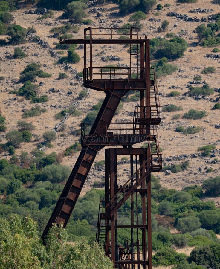 Rusty Industrial Tower Stands Isolated Against a Dry Hillside Covered ...
