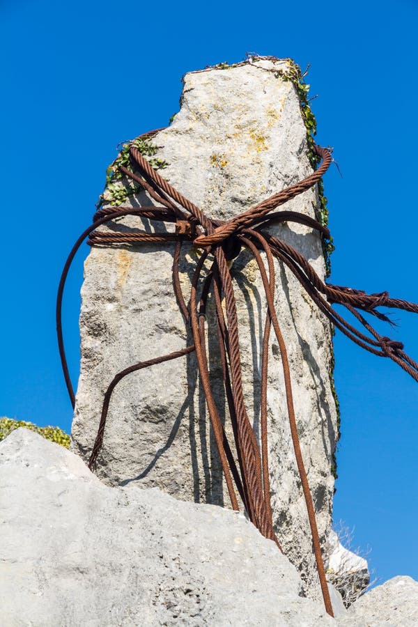 Rusty Iron Cables Looped Around Limestone Rock. Stock Image - Image of ...