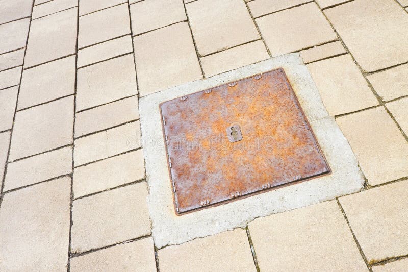 Rusty Iron Cast Manholes in a Modern Stone Paving Stock Image - Image ...