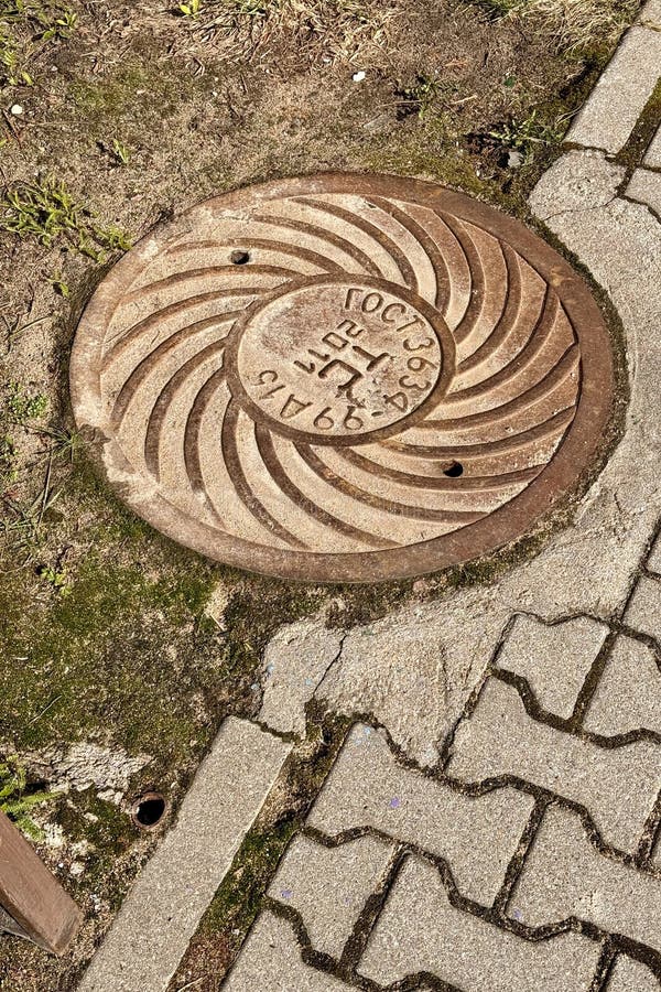A Rusty Iron Hatch with a Pattern is Mounted in the Asphalt Pavement of ...