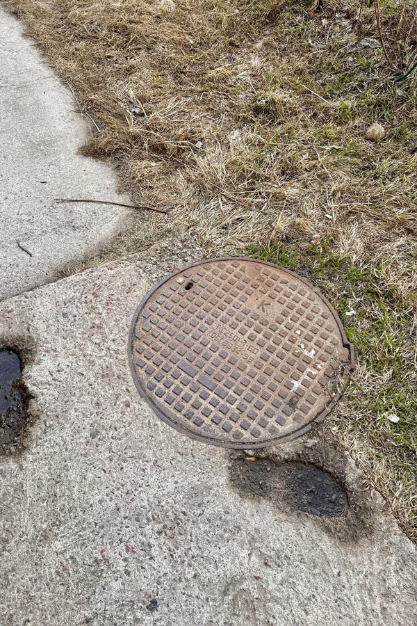 A Rusty Iron Hatch with a Pattern is Mounted in the Asphalt Pavement of ...