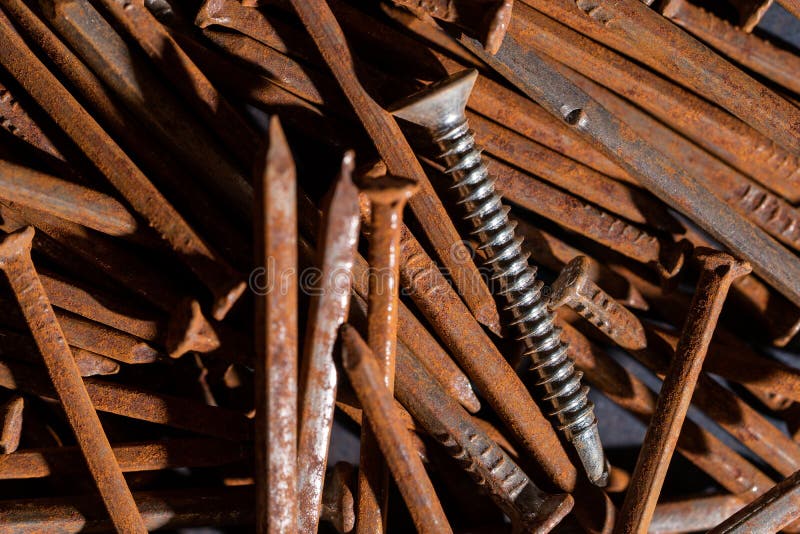 Rusty Iron Nails Piled Up in Disarray and a New Chrome on Top Stock ...