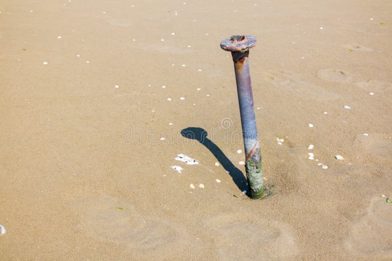 Rusty Iron Pole in Sand of Beach at North Sea Coast, Netherlands Stock ...