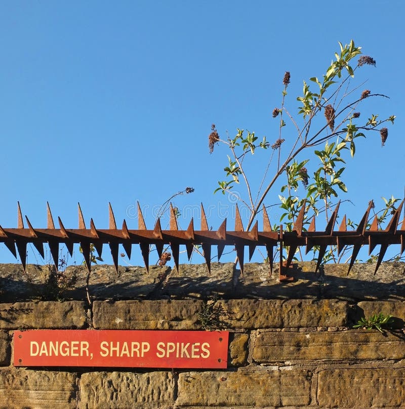 Rusty Iron Sharp Spikes on the Top of an Old Stone Wall with a Red ...