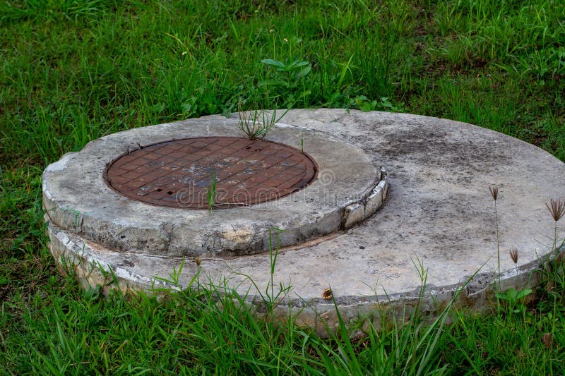 Rusty Manhole Cover Set in Weathered Concrete Stock Image - Image of ...