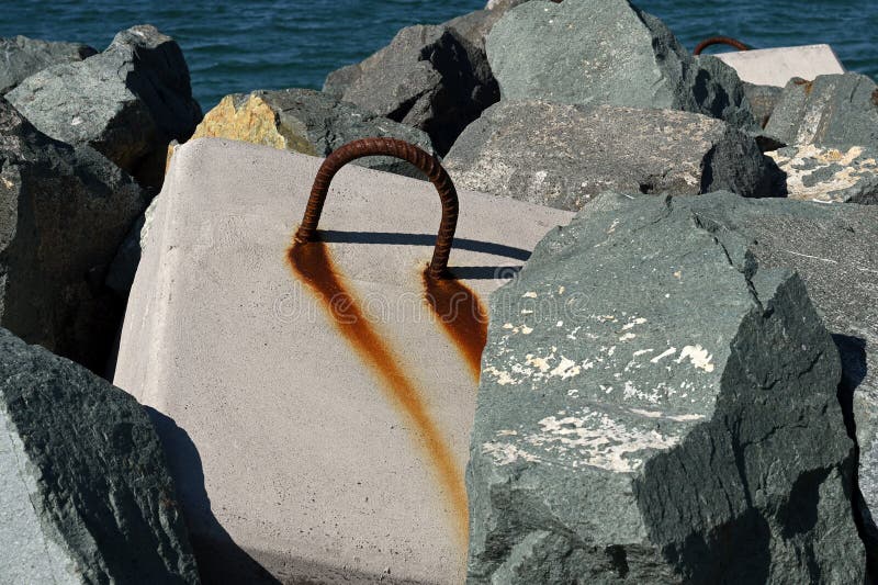 Rusting Metal Bar in a Concrete Cube on an Ocean Retaining Wall Stock ...