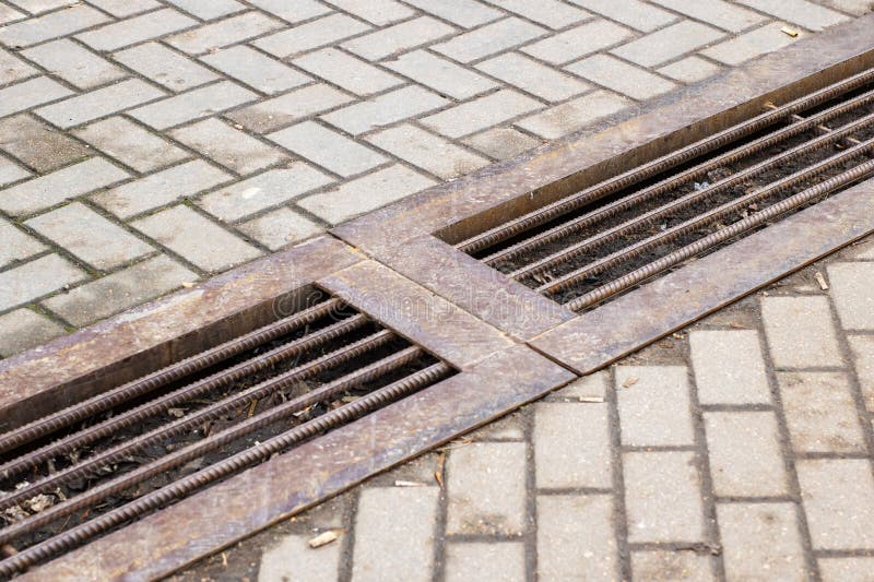 A Rusty Metal Grate is Currently Sitting on a Weathered Brick Sidewalk ...