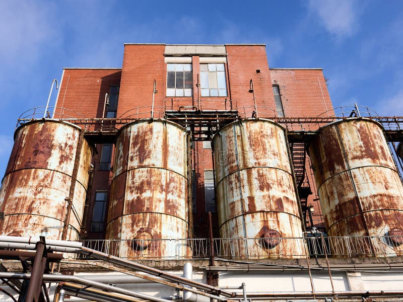 Rusty Industrial Silos Against a Blue Sky and Brick Building Editorial ...
