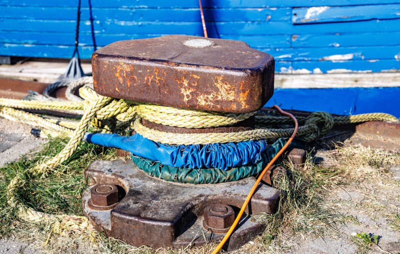 Rusty Mooring Bollard with Yellow Rope Securing Boat on a Dock Stock ...