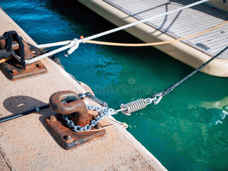 Rusty Mooring Bollards with Chains and Ropes Tied To Them in a Harbour ...