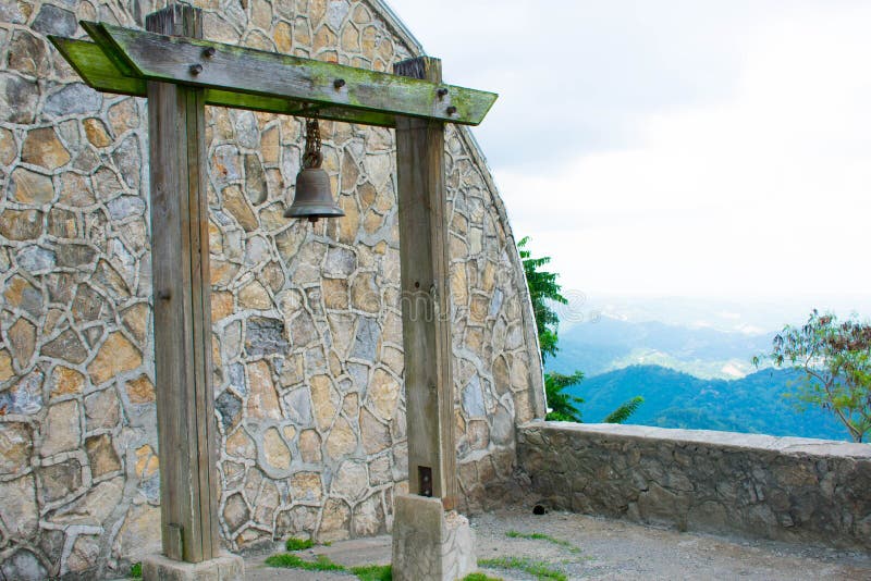 Rusty Old Bell Hanged in Mossy Wood Pillar with Stone Pattern Arc Wall ...