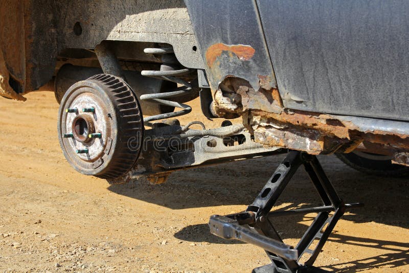 Rusty Old Car Up on Jack during a Tire Change Stock Image - Image of ...