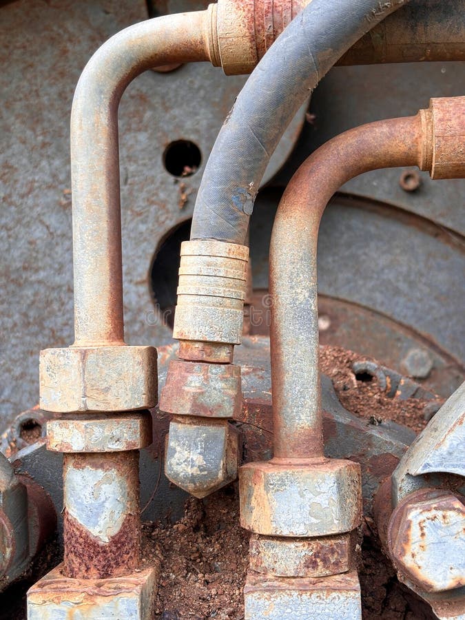A Rusty Pipe with Three Different Colored Pipes Coming Out of it Stock ...
