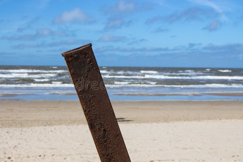 Rusty pole on beach stock photo. Image of holland, stake - 69671724