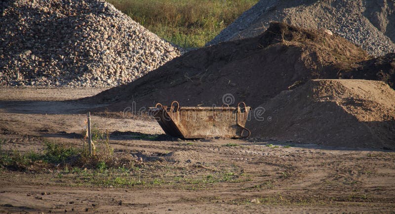 Rusty Skip Bin in a Construction Site with Piles of Gravel and Earth ...