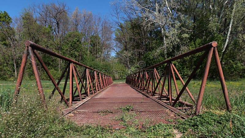 Rusty Pedestrian Bridge with Grate Floor As Pathway Across Artificial ...
