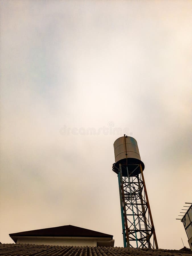 Rusty water tower at noon stock image. Image of water - 249990281