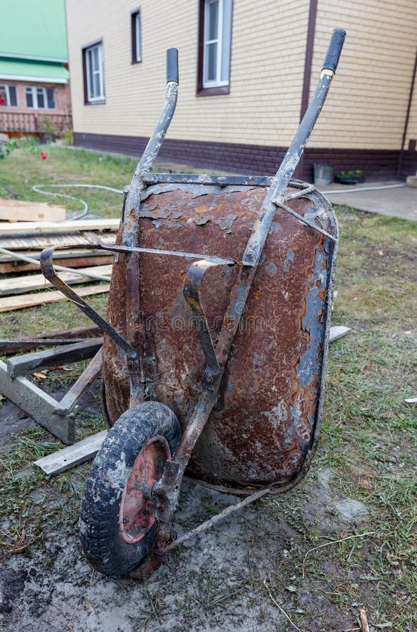 A Rusty Wheelbarrow is Sitting in a Yard Stock Image - Image of ...
