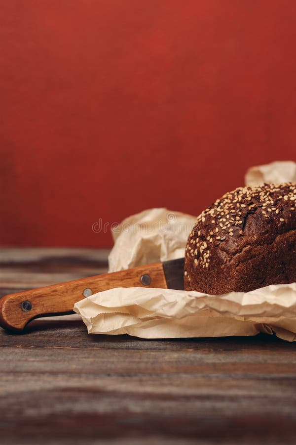 Rye Bread on Paper Packaging on a Red Background and a Wooden Table ...