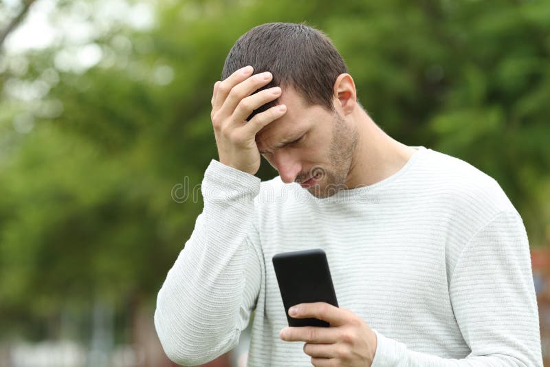 Sad Adult Man Checking Phone Message in a Park Stock Photo - Image of ...