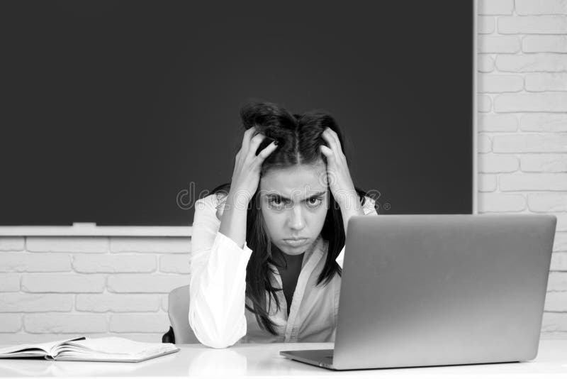 Sad and Angry Student Using Computer in Classroom. Stock Photo - Image ...