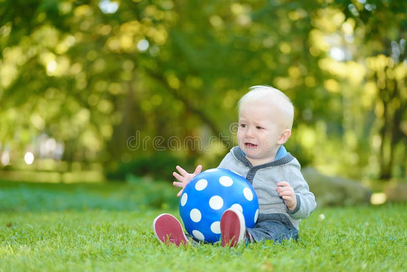 Sad Baby Sitting in the Green Grass Stock Photo - Image of beauty, fall ...