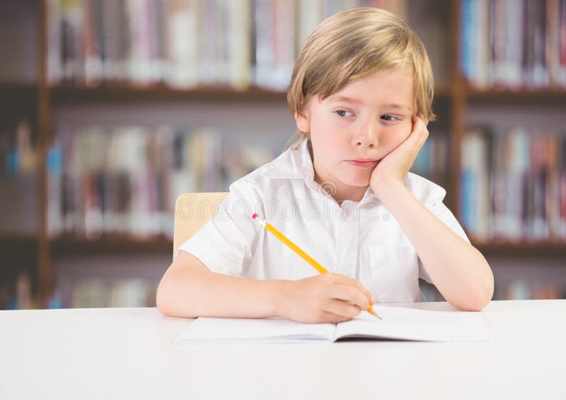 Sad Bored Boy at Desk Against Bookshelves Stock Photo - Image of higher ...