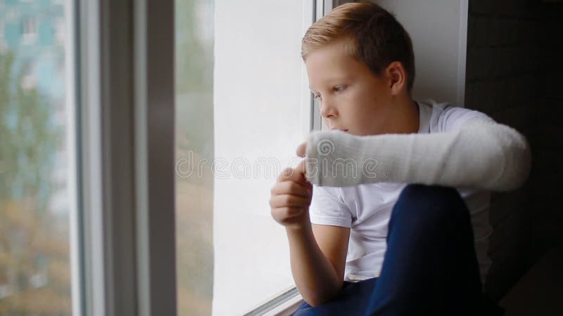 Sad Boy with Broken Hand Looking at the Window Stock Video - Video of ...