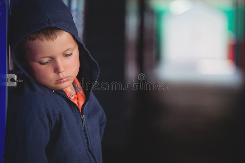 Sad boy leaning on locker stock photo. Image of gloominess - 92596888