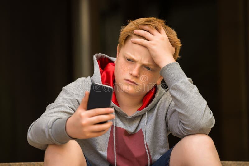 Sad Boy Looking at Mobile Phone Stock Photo - Image of pressure, people ...