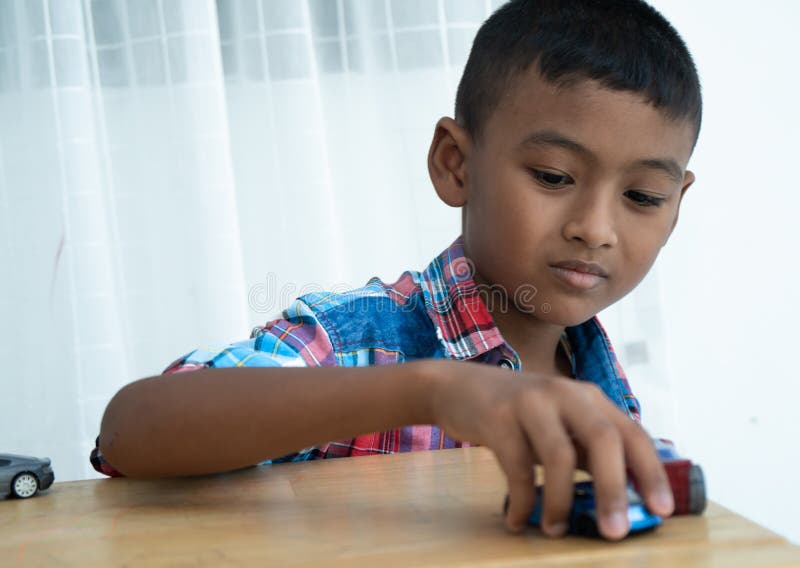 Sad Little Boy Lying on the Table and Play Toy Car Stock Image - Image ...