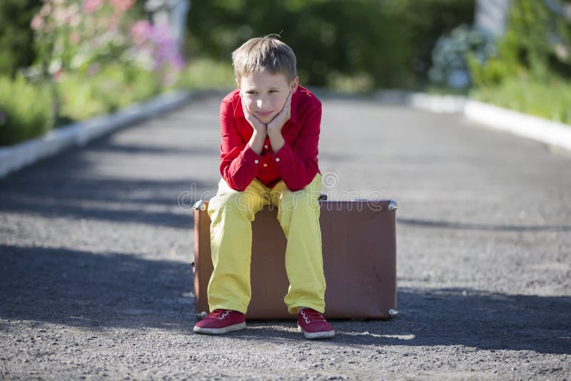 A Sad Boy Sits on an Old Suitcase on the Road. Stock Photo - Image of ...