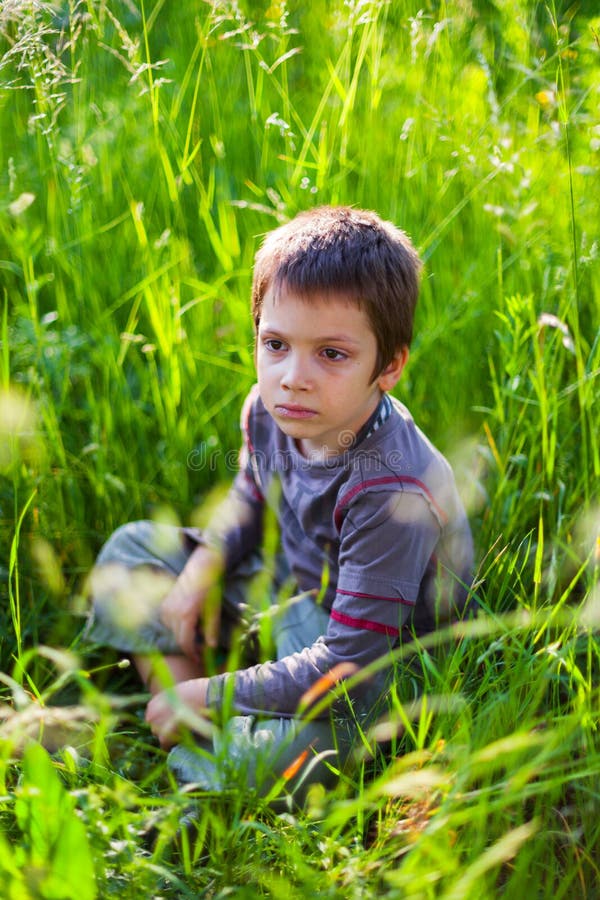 Sad boy sitting in grass stock image. Image of thinking - 38876453