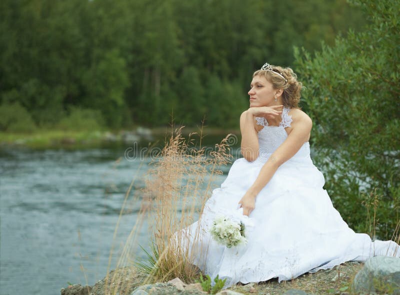 Sad Bride Sits on River Bank Stock Image - Image of dress, flowers ...