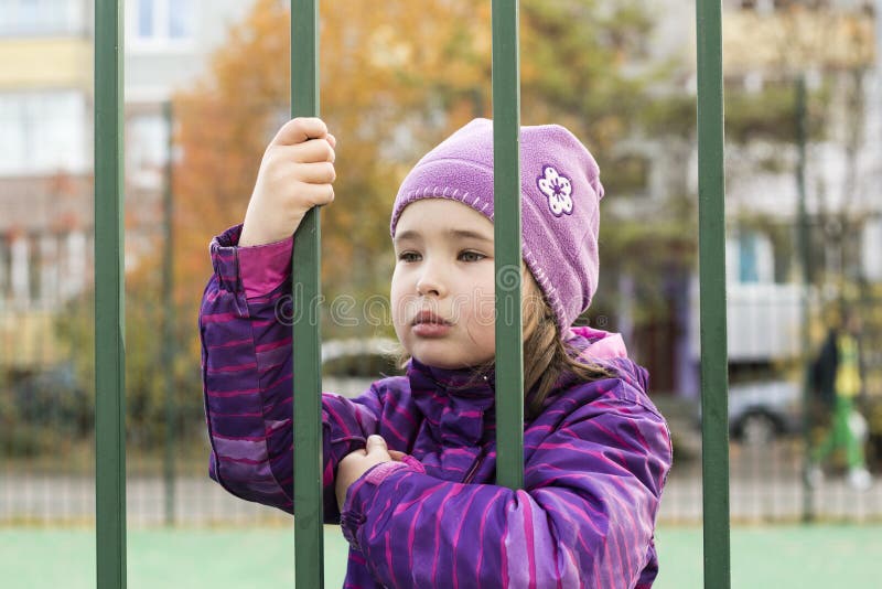 Sad child in jail stock image. Image of yard, girl, fence - 61542473