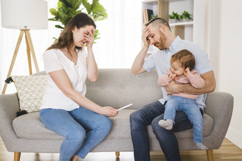 Sad Couple with Pregnancy Test at Home Interior with Baby Stock Photo ...