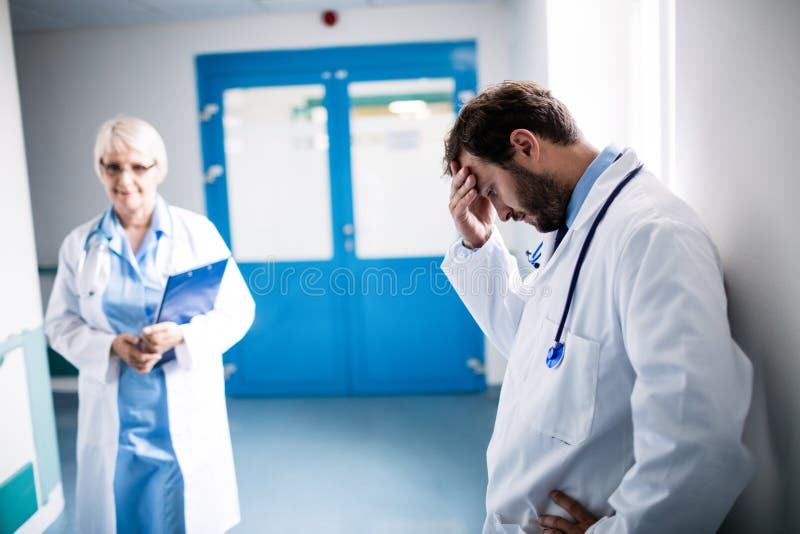 Sad Doctor Leaning Against the Wall Stock Photo - Image of holding ...