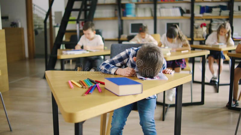 A Sad Elementary School Student in a Blue Plaid Shirt is Being Fussy, Crying, and Refusing To ...