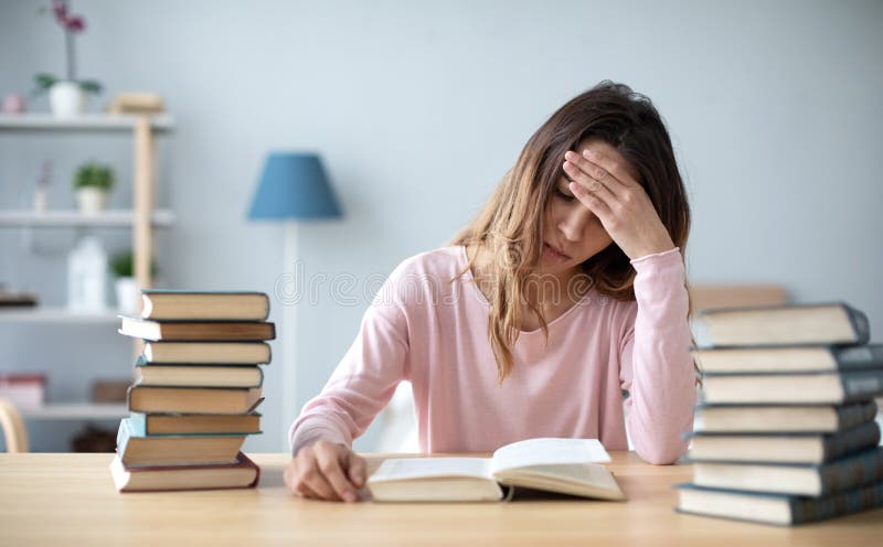 Sad Female Student Reading a Book for the Exam or Doing Homework Stock ...