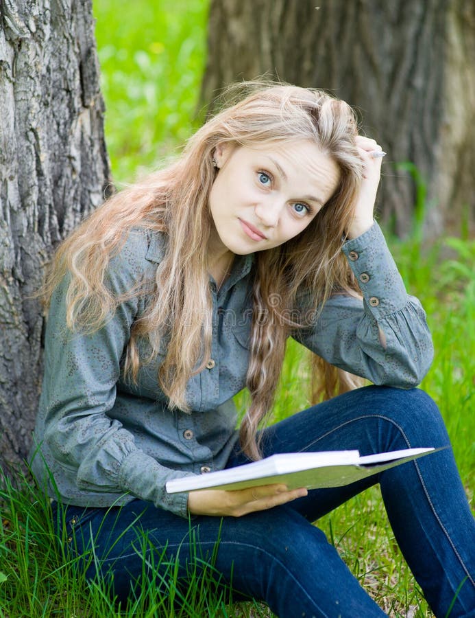 Sad Girl Sitting on Grass and Reading a Book Stock Photo - Image of ...