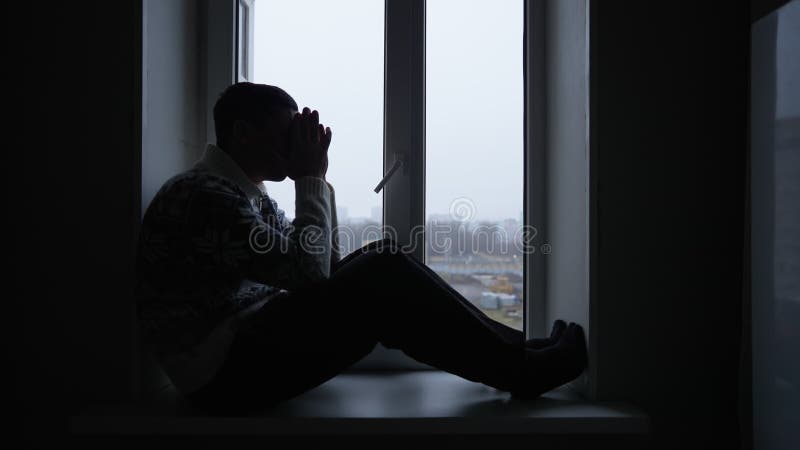 Sad Guy Suffers from Depression while Sitting on the Windowsill at Home ...